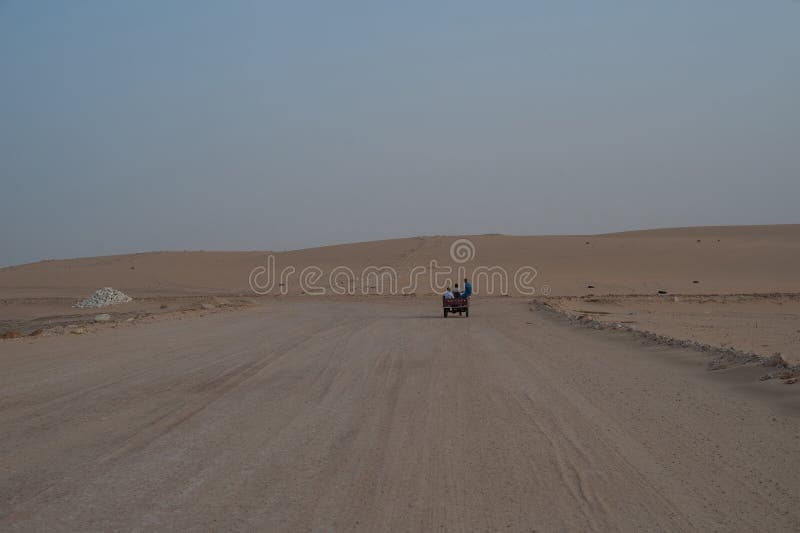 Horizontal Shot of Desert Road and a Small Chariot Carrying Three ...