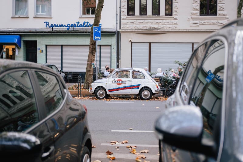 A Horizontal Shot of a Mini Cooper with Martini Advertising on the Road ...