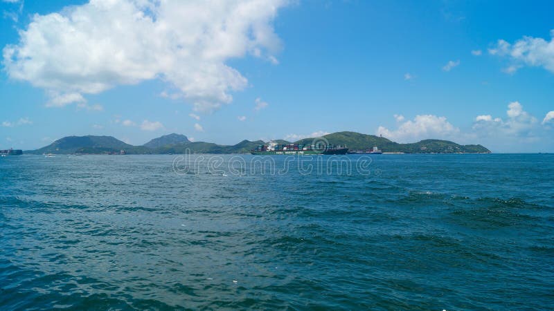 Horizontal View of Sea with a Container Ship with Mountains Under the ...