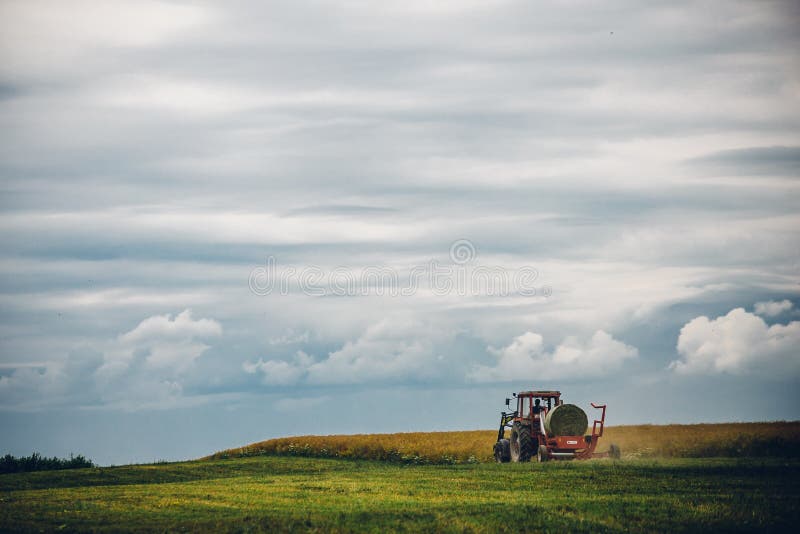 Horizontal View of a Tractor in a Green Field Under the Blue Sky ...