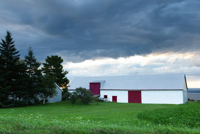 Horizontal View of a White Barn Seen Under a Dramatic Sky during a Late ...