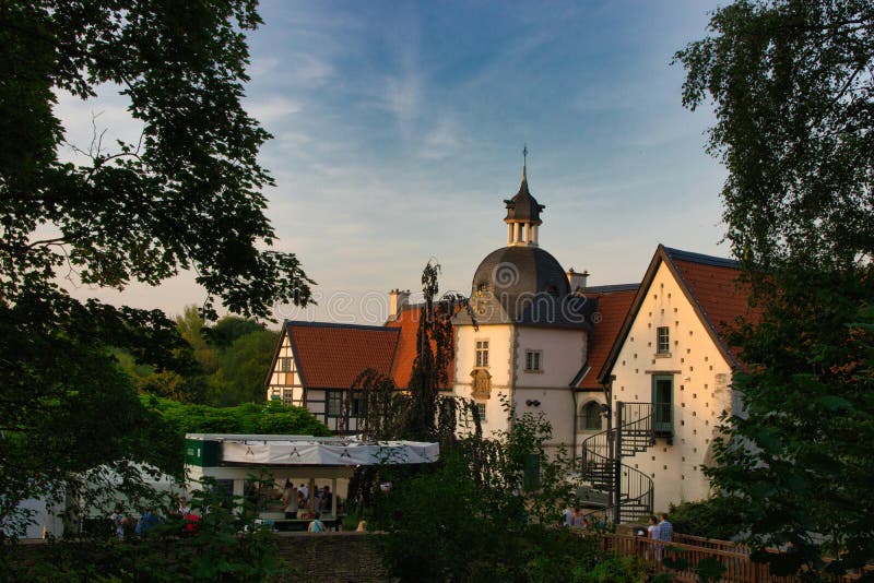 Horizontal View of a White Building with Brown Roof and a Garden in ...