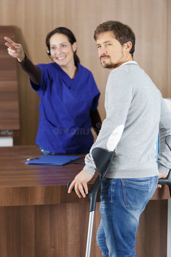 Hospital Receptionist Pointing Injured Patient in Right Direction Stock ...