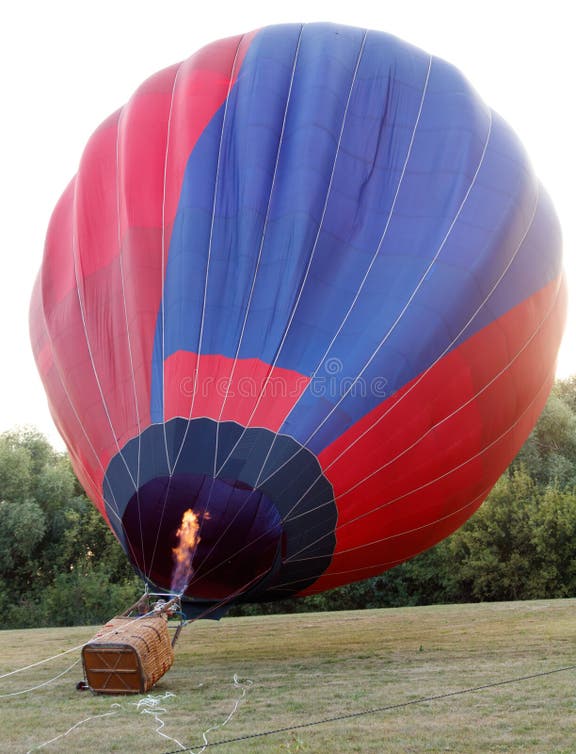 A Hot Air Balloon is in the Air with a Fire Burning Inside Stock Image ...