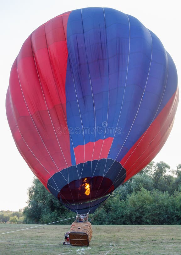 A Hot Air Balloon is in the Air with a Fire Burning Inside Stock Photo ...