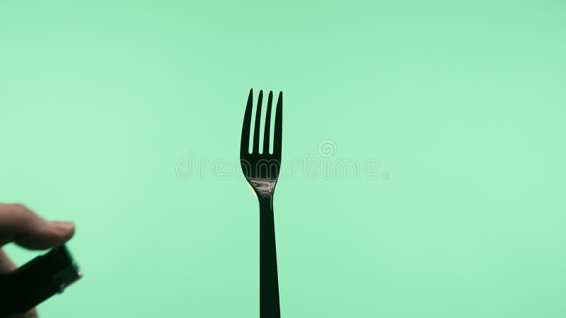 Hot Flame Gas Lighter Burns Black Disposable Plastic Fork on Green ...