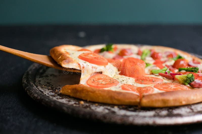 Hot Pizza Slice with Melting Cheese on a Rustic Black Table. Stock ...