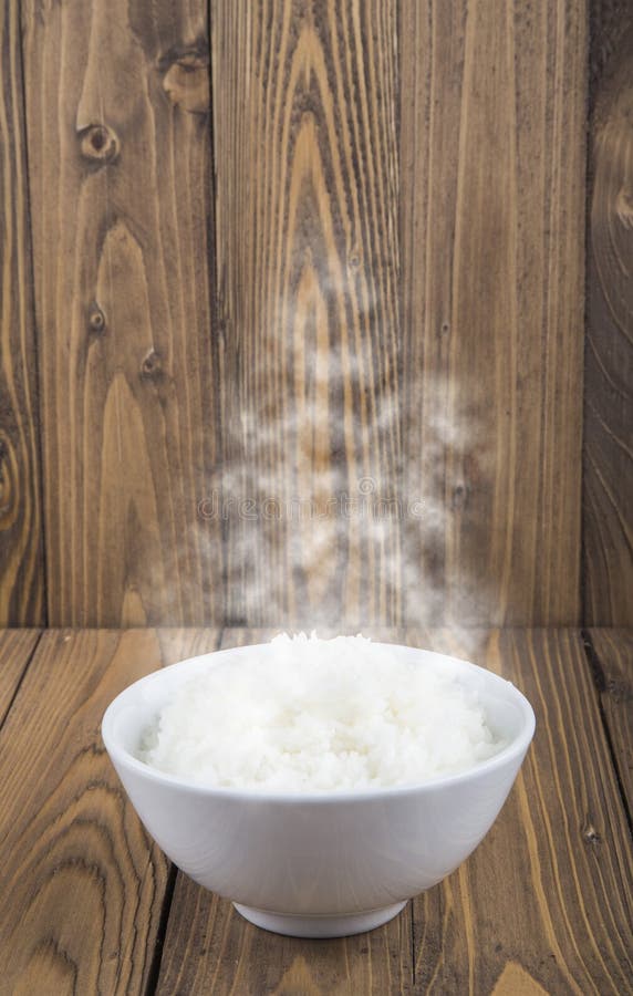 Hot Steamed Rice in a White Bowl with White Vapor on Wooden Background ...