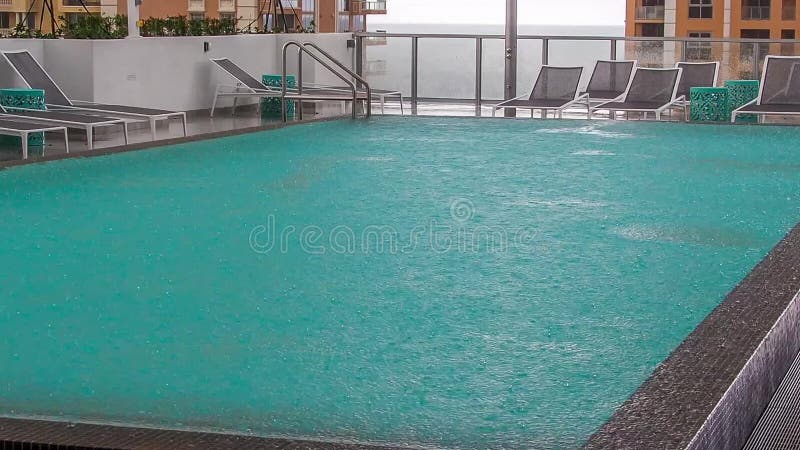 Hotel pool in rainy day stock video. Video of drops - 105562607