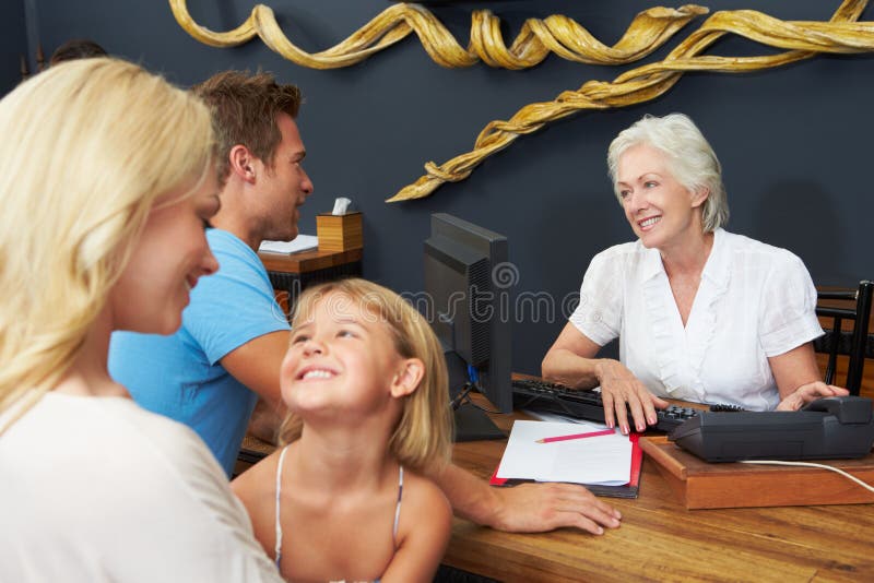 Hotel Receptionist Helping Family To Check in Stock Image - Image of ...