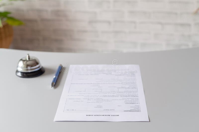 Hotel Reservation Form and Silver Vintage Bell on Reception Desk with ...