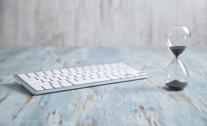 Hourglass with a Computer Keyboard on the Desk Stock Photo - Image of ...