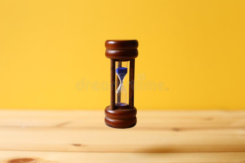 Hourglass Floating on Wooden Table Stock Photo - Image of deadline ...