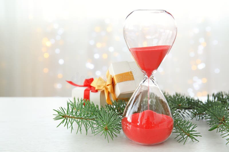 Hourglass, Gifts and Festive Decor on Table. Christmas Countdown Stock ...