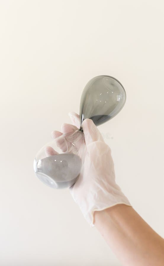 Hourglass Held by a Gloved Hand in Front of Desk Stock Image - Image of ...