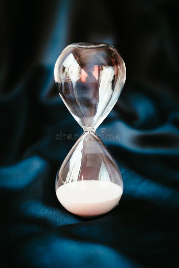 An Hourglass with Pink Sand at the Bottom of the Clock is on a Blue ...