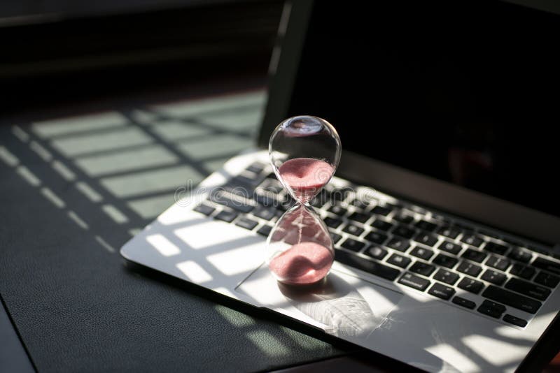 Hourglass Sand Timer on Top of Laptop Stock Image - Image of passing ...