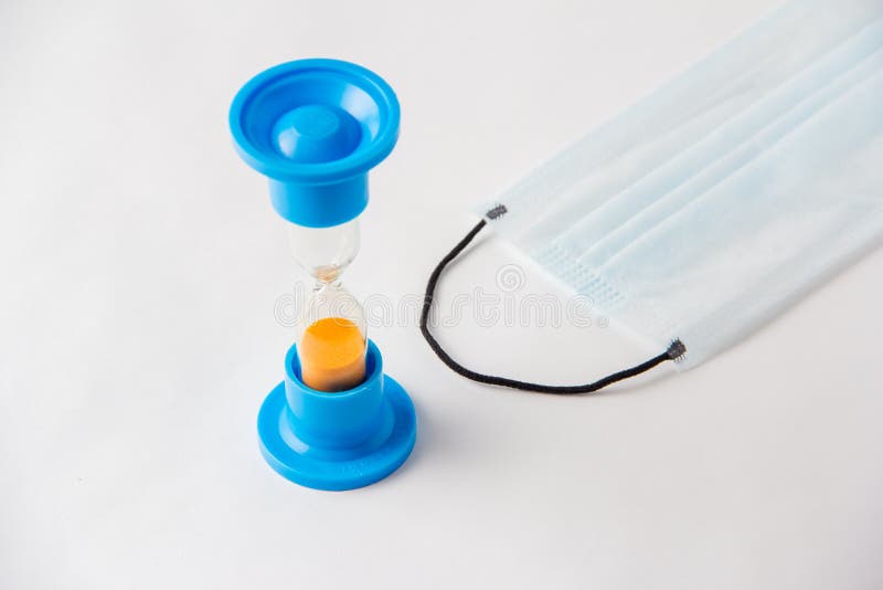 Hourglass Shows Time in the Background with Medical Mask Stock Photo ...