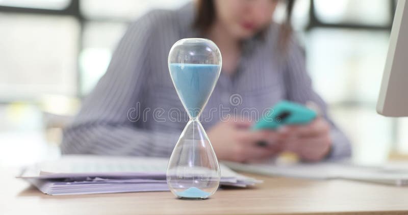 Hourglass is on Table, in Background Manager is Using Smartphone Stock ...