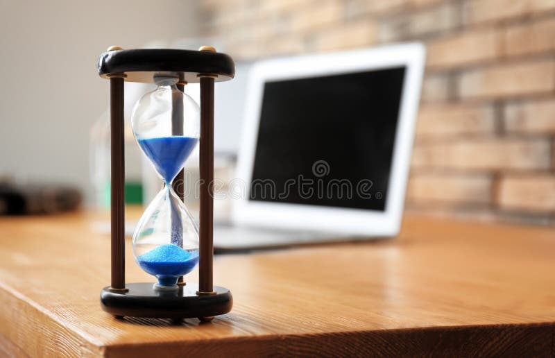 Hourglass on Table in Office. Time Management Concept Stock Photo ...