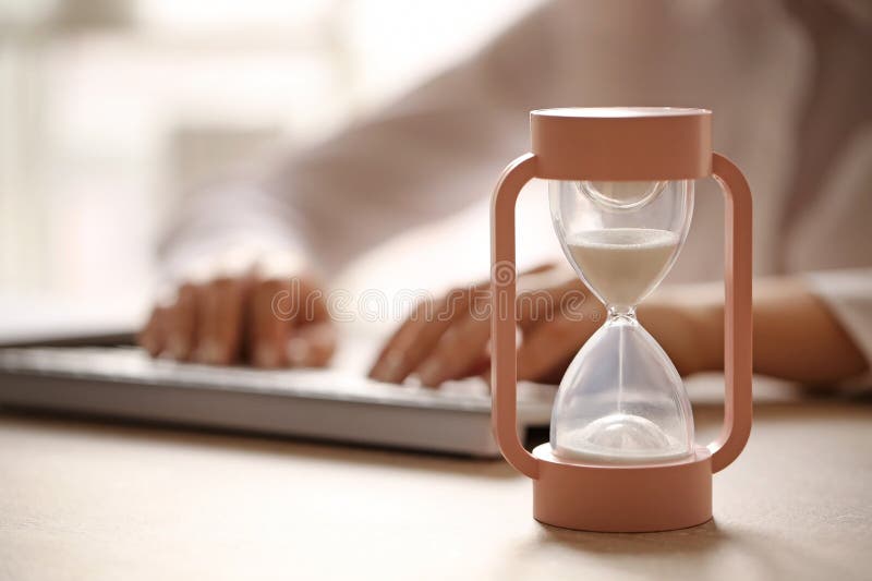 Hourglass and Woman Working on Computer at Table in Office Stock Image ...