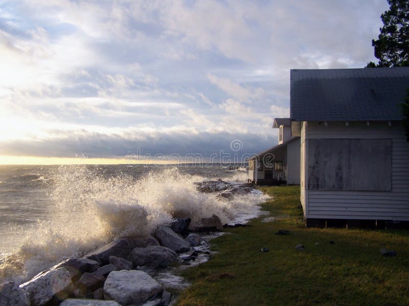 A House is on a Beach with a Large Wave Crashing into the Shore Stock ...