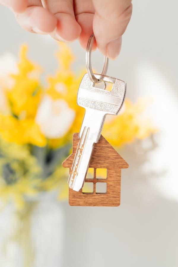 A House Key with a Keychain in the Form of a Wooden House on a Light ...