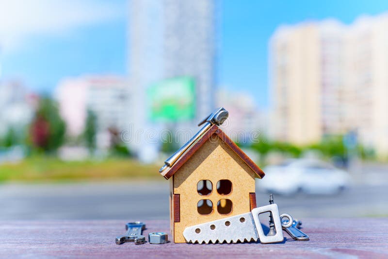 House Model and Tool Replicas with a Cityscape Backdrop Stock Photo ...