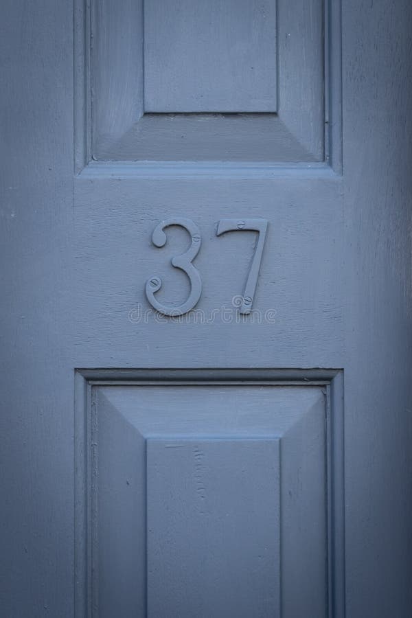 House Number 47 on a White Plaque on a Dark Green Wooden Front Door ...