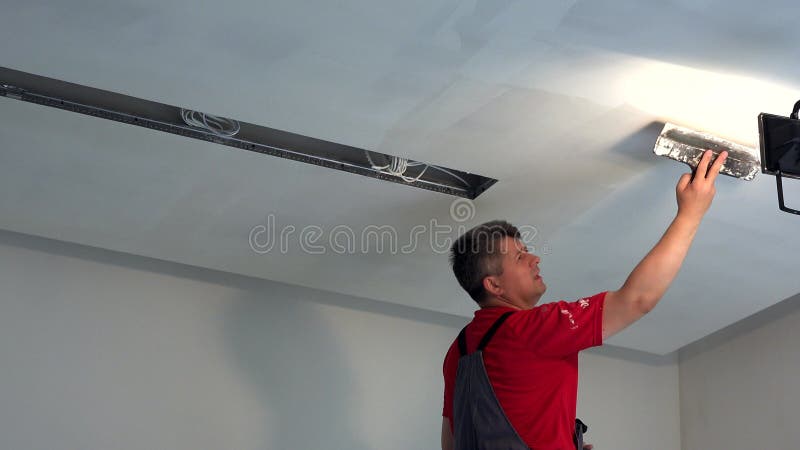 House Refurbishment. Worker Spackling Ceiling with Putty Stock Footage ...