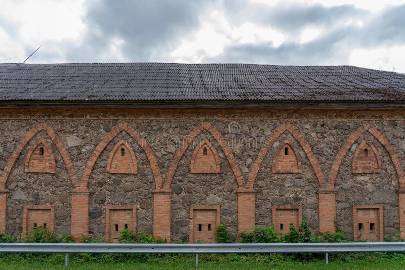 House Wall Made of Stones and Red Bricks with Many Arched Markings ...