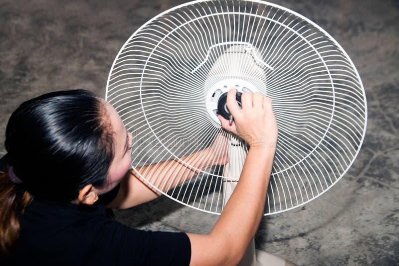 The Maidservant Is Assembling And Installing An Electric Fan After ...