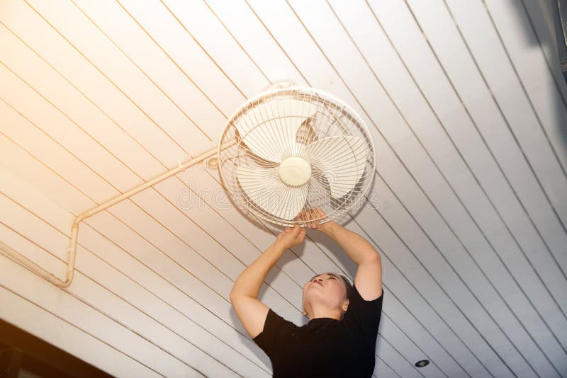 The Maidservant is Installing and Cleaning the Ceiling Fan. Stock Photo ...