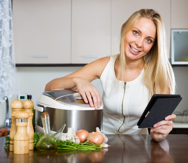 Housewife Reading Ereader and Cooking with Multicooker Stock Photo ...