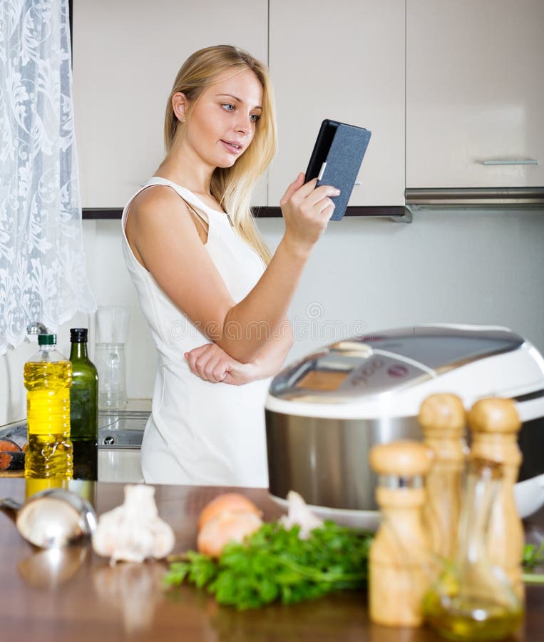 Housewife Reading Ereader and Cooking with Multicooker Stock Photo ...