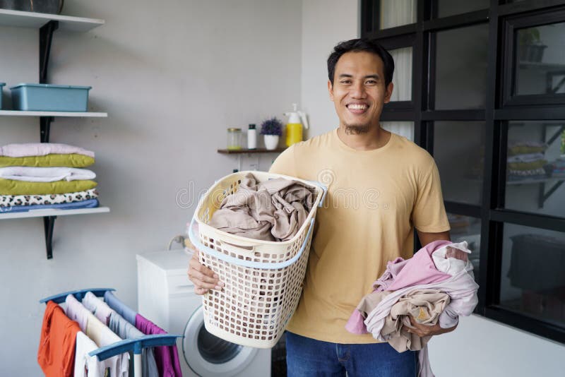 Housework. Asian Man Loading Clothes into Washing Machine Stock Image ...