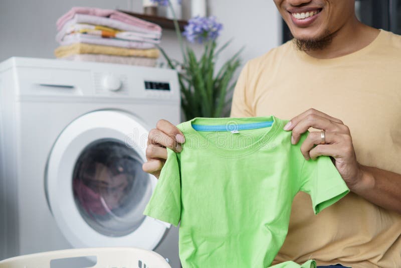 Housework. Asian Man Loading Clothes into Washing Machine Stock Image ...