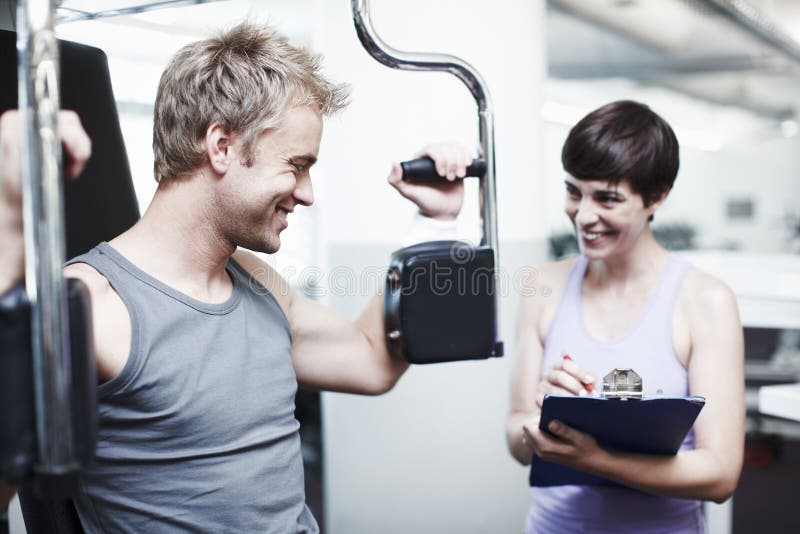 How am I Doing, Coach. a Handsome Young Man Using an Exercise Machine ...
