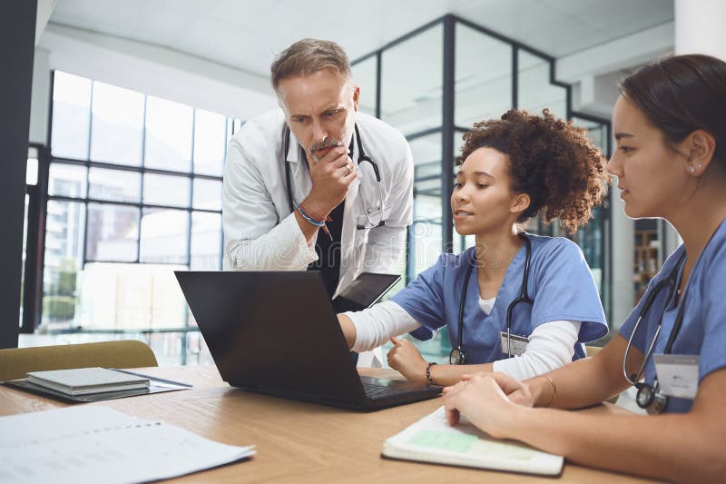 How Should we Proceed with this. a Team of Doctors Using a Laptop ...