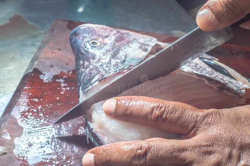 How To Scrape Tilapia Fish Using a Knife,man Wiping a Fish on a Wooden ...