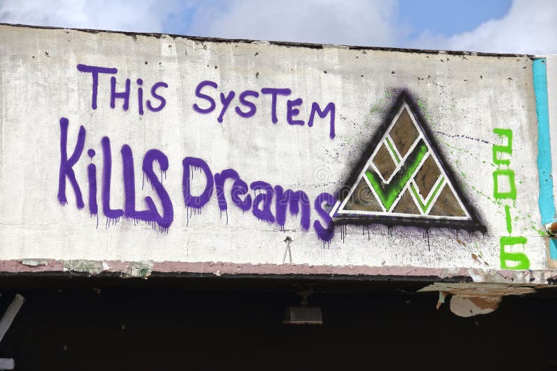A Very Large Sign with Graffiti Writing that Says this System Kills ...