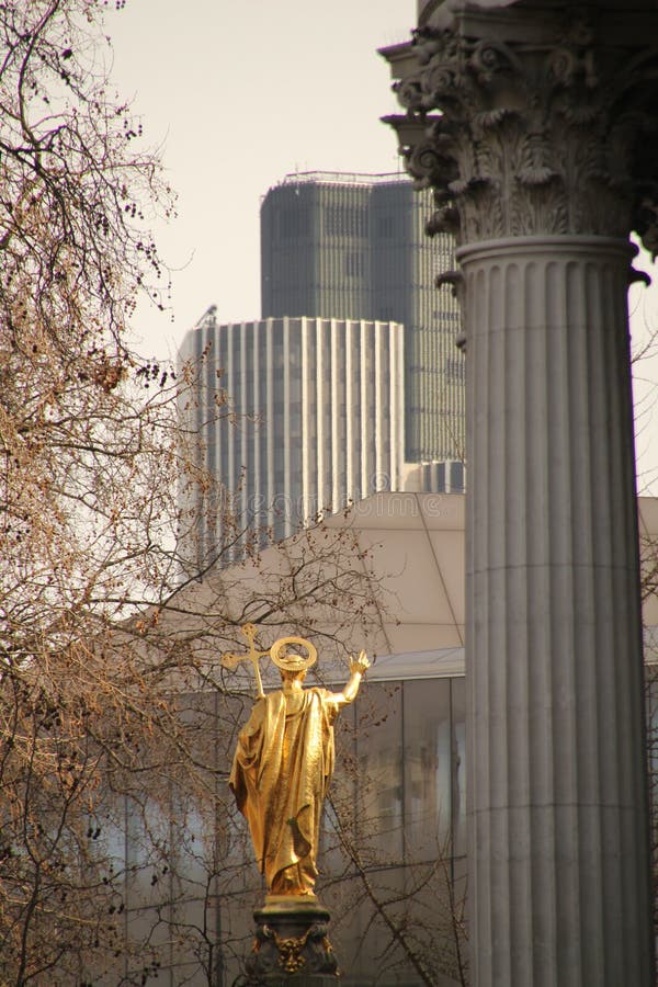 Huge Column of an Old Building and Golden Statue of a Man with Cross in ...