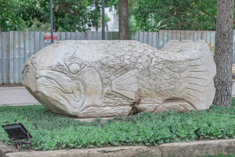 Sculpture of Two Fish Standing on Their Tails and Holding Boat with Man ...