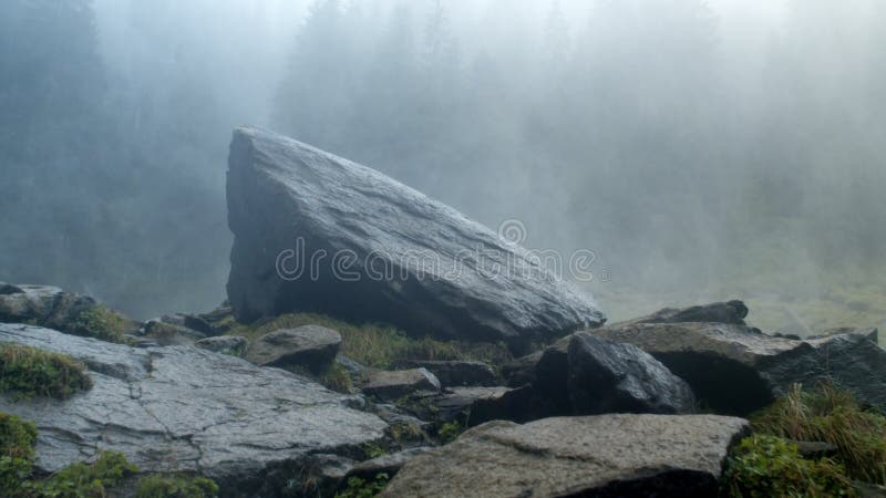 Huge Rock Next To Waterfall with Wind Pushing Water into the Air Stock ...
