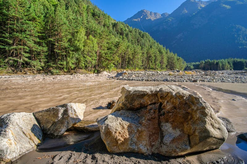 A Huge Stone Boulder Against the Backdrop of a Turbid Muddy River in a ...