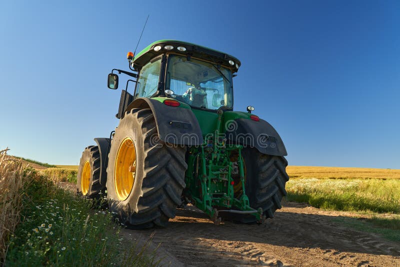 Big tractor in wheat field editorial stock photo. Image of machine ...