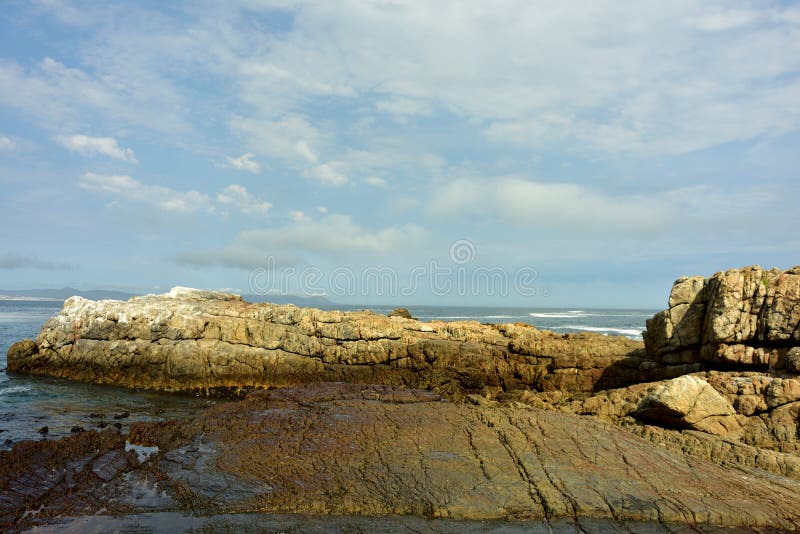 A Huge and Wet Rock Ridge with the Sea and Interesting Stringing Clouds ...