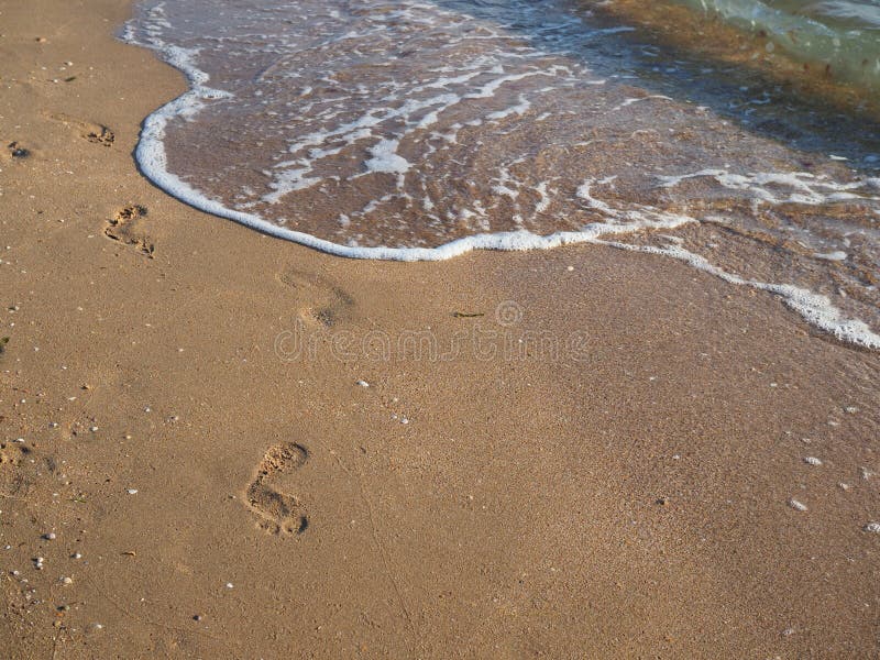 Human Footprints on the Sand Beach,wave Washes Away the Traces Stock ...