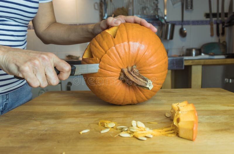 Human hand cutting pumpkin stock photo. Image of pumpkin - 232861886