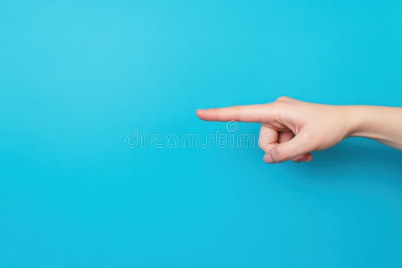 A Close Up of a Human Hand Pointing To the Left Against a Vibrant Blue ...